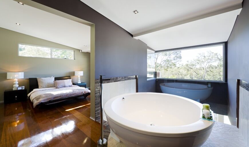A modern, open-concept master suite with a bathroom just around the ...